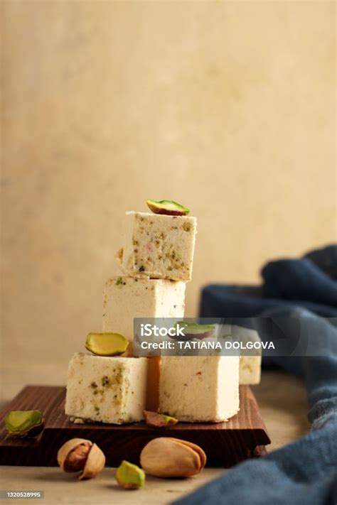 천연 비건 제품 밝은 배경에 나무 보드에 피스타치오와 할바 터키어 아랍 유대인 국가 과자 전통적인 동양 디저트 Chekme 공간을 복사합니다 수직 위치 0명에 대한 스톡