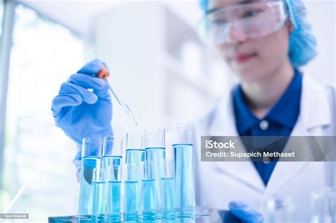 전문 과학자 화학자 기술자 분석 연구 실험 바이러스 파란색 액체 피펫 유리 시험관 장비 병원 실험실 여성 의사 흰색 실험실 코트 의료 연구 개발 피펫에 대한 스톡 사진 및