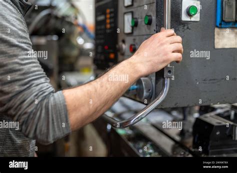 Worker Pressing Buttons On CNC Machine Control Board In Factory High Quality Photography Stock