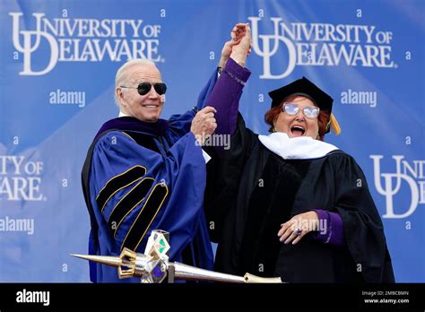 President Joe Biden Holds Up The Hand Of Honorary Degree Recipient