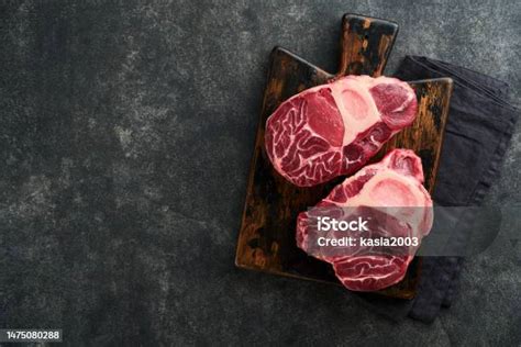 오소 부코 생 스테이크 고기 바베큐 고기 원시 신선한 크로스 컷 송아지 정강이와 조미료 후추 로즈마리 백리향 및 어두운 배경에 소금 쇠고기 다리 슬라이스 이탈리아어 메뉴