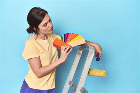 Женщина с цветовой палитрой рисует стену на лестнице Премиум Фото