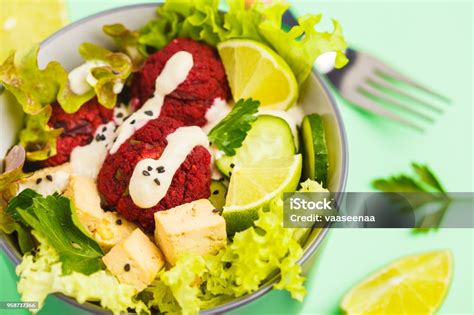 근대 미트볼 야채 Tahini 드레싱과 구운된 두 부 채식주의 부처님 그릇 녹색 배경 평면도 복사 공간입니다 건강 한 채식 음식