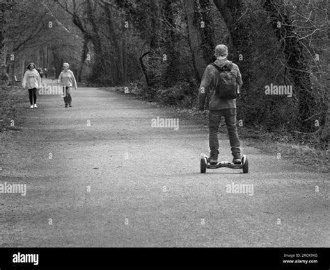 A Man Rides His Battery Powered Hoverboard Down A Nature Trail