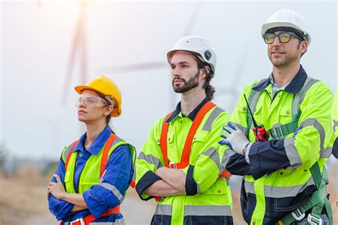 팀워크 엔지니어는 안전 유니폼을 입고 풍력 터빈 분야에서 팔짱을 끼고 서 있다 기술은 환경을 보호하고 지구 온난화 문제를 줄입니다 대체 에너지 개념입니다 35 39세에 대한