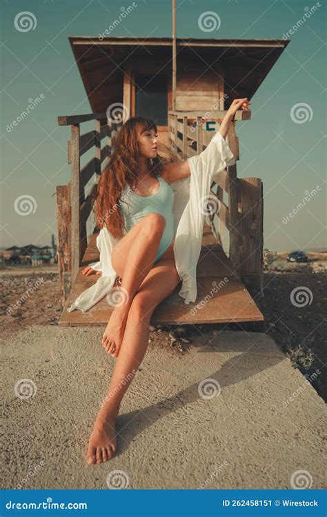 Vertical Shot Of A Brunette Female Model Posing At A Beach In Cyprus Wearing A Swimsuit Stock