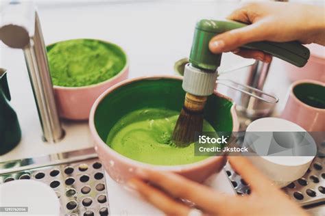 현대 전기 거품기로 채찍질하는 말차 분말의 공정 바리스타는 아시아 카페에서 현대적인 티웨어 도구를 사용하여 천연 거품 이마 차를 만듭니다 채식 카페에서 천연 녹차 준비