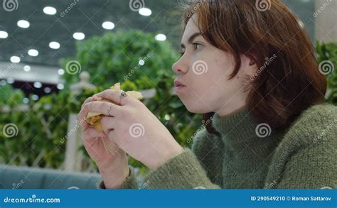 A Young Girl Eating A Hamburger In Fast Food Restaurant Stock Footage
