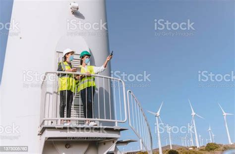 전염병 동안 풍력 발전 단지에서 풍력 터빈에서 작업하는 보호 면 마스크를 가진 여성 엔지니어 25 29세에 대한 스톡 사진 및
