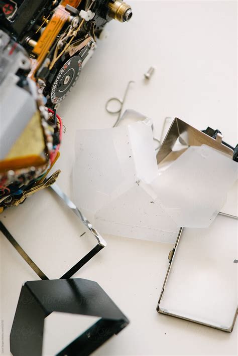A Broken Camera Laying On Its Side Parts Scattered By Stocksy