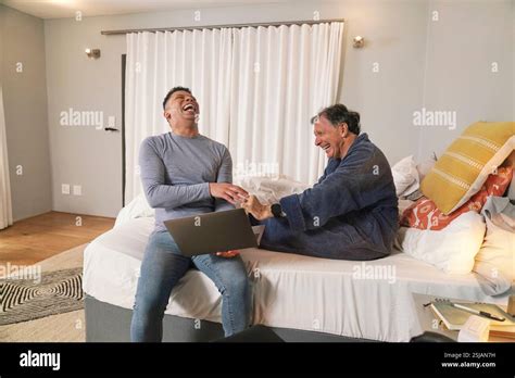 Home Caregiver And Disabled Man Sitting On Bed Laughing Stock Photo Alamy