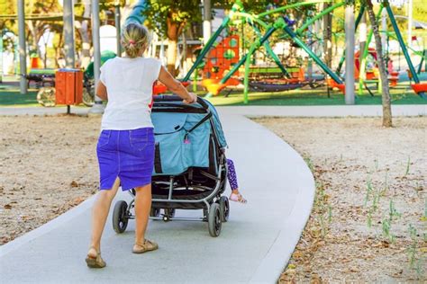 Premium Photo Woman With Baby Stroller Walks In The Park
