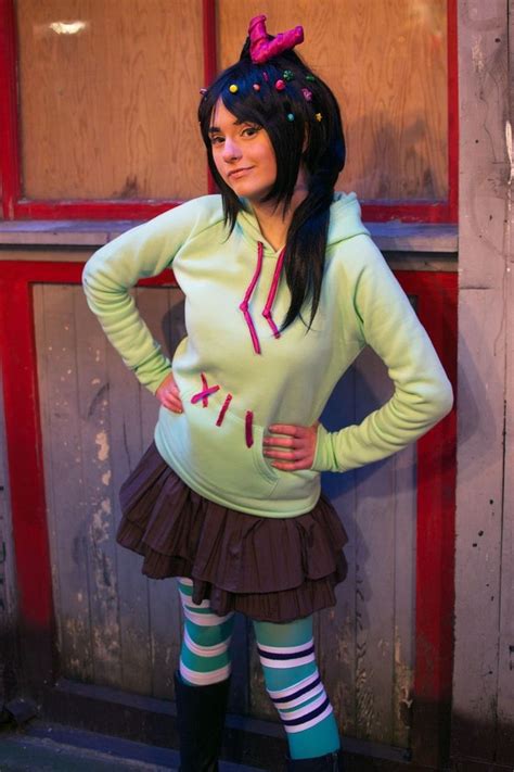 A Woman In A Green Shirt And Skirt Posing For The Camera With Her Hands On Her Hips