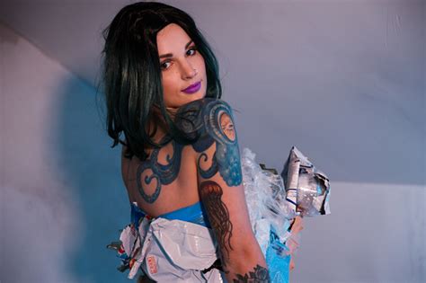 플라스틱과 골판지로 만든 쓰레기 드레스를 입고 웃는 여성 에코 파이터의 초상화는 오염 인식 개념에서 환경 청소 자연을 확산하는