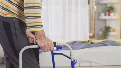 A Senior Man Using A Walker In A Rehab Center Or Nursing Home Patient