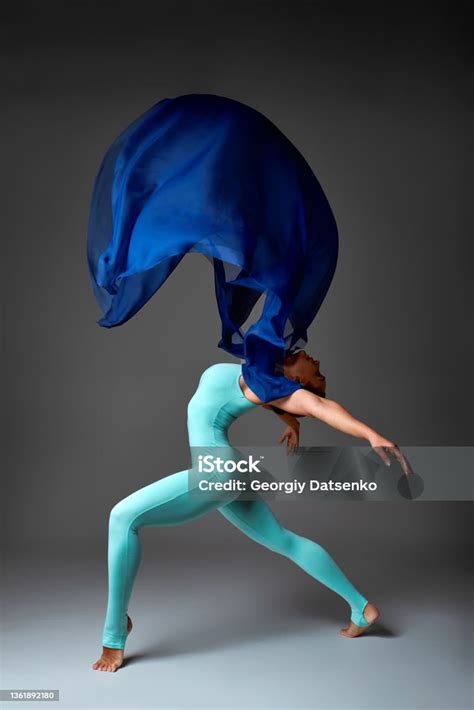 실크 패브릭으로 춤추는 발레리나 흔들리는 천 회색 배경의 현대 발레 댄서 Theatrical Performance에 대한 스톡