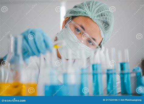 Female Researchers Are Experimenting With Pipette Dropping A Sample Into A Test Tube In An