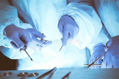 Surgeons Hands Holding Surgical Scissors And Passing Surgical Equipment