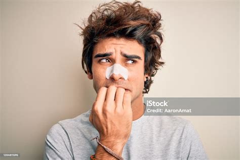 젊은 잘 생긴 남자 코 스트립 을 사용하여 고립 된 흰색 배경 위에 서 스트레스와 손톱을 물고 손에 긴장 찾고 불안 문제 블랙