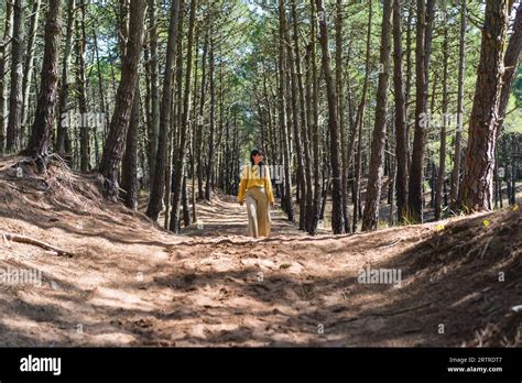 Adult Woman Walking Over A Path Under The Trees In The Forest Stock Photo Alamy