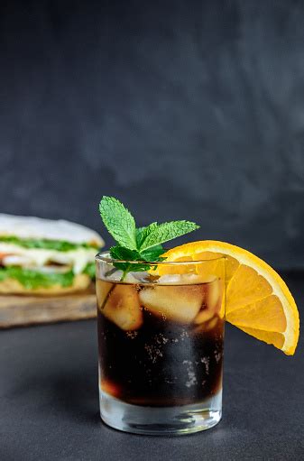 큰 샌드위치 거리 음식으로 칵테일 마시고 음식을 빨리 쇠고기와 함께 수 제 햄버거 나무 테이블에 치즈 검은색에 레몬 민트와 얼음 콜라의 오렌지 민트 유리 0명에 대한 스톡
