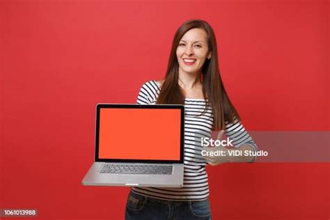 아름 다운 젊은 여자 엄지를 보여주는 밝은 빨간 벽 배경에 고립 된 빈 블랙 빈 화면으로 노트북 Pc 컴퓨터를 들고 사람들이 진심으 감정 라이프 스타일 개념 복사 공간을