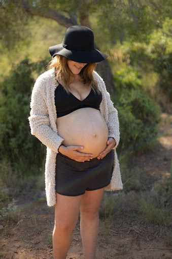 검은 옷과 모자와 베이지 색 풀오버를 입은 임산부가 사랑과 출산 흥분과 책임감을 느낍니다 30 39세에 대한 스톡 사진 및 기타