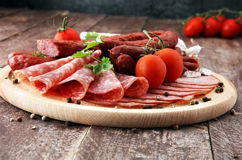 맛 있는 살라미 슬라이스 햄 소시지 토마토 샐러드 야채 고기 플래터 선택절단 소시지와 기념 테이블에 치유 고기 조각의 식품