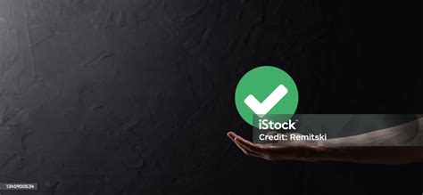 손은 녹색 아이콘 확인 마크를 보유하고 마크 기호를 확인 진드기 아이콘 오른쪽 기호 녹색 체크 마크 버튼 도 어두운 배경에 배너복사 공간 텍스트에 대 한 배치 개념에 대한