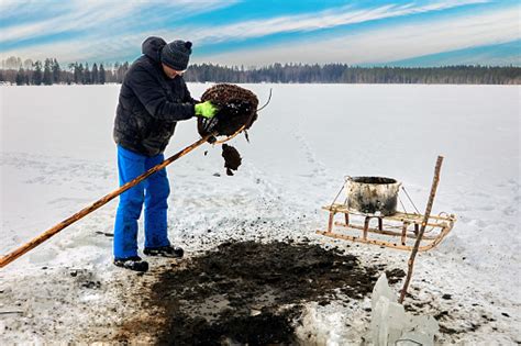 농부는 농업을 위해 얼음 구멍을 통해 기둥에 바구니를 사용하여 호수 실트 사프로펠을 추출하고 유기 물질을 썰매로 옮겨 토양을 자연적으로 비옥하게 합니다 55 59세에 대한