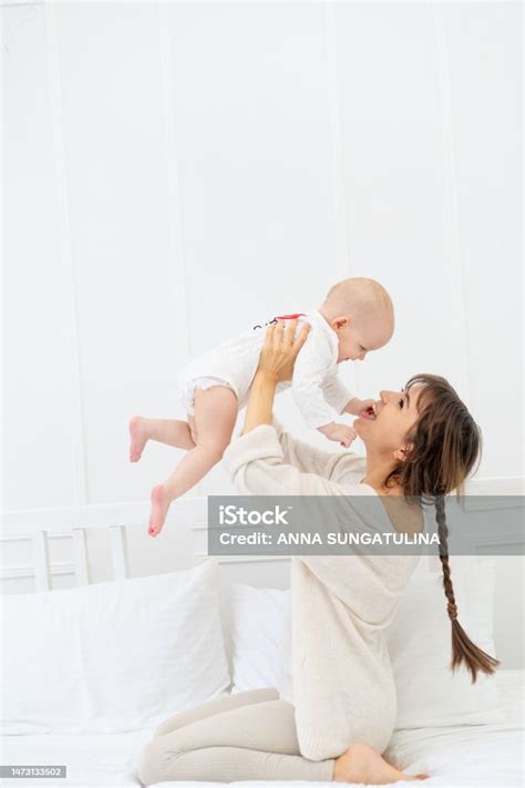 침대에서 집에서 아기 딸과 함께 행복 한 엄마 포옹과 키스 행복 한 젊은 엄마와 모성 2 5 개월에 대한 스톡 사진 및 기타 이미지 2 5 개월 2명 30 34세