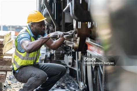 남성 엔지니어 유지 보수 기관차 엔진 기관차 수리 차고에서 안전 유니폼 헬멧 및 장갑을 착용 남성 철도 엔지니어는 기차 차고에서 렌치 수리 기차 바퀴를 사용합니다 25 29