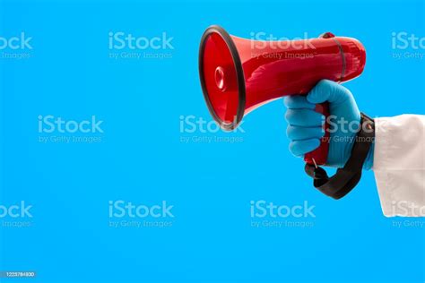 라텍스 보호 장갑과 흰색 실험실 코트에 메딕 손으로 의사 조언 및 의료 발표 개념 클리핑 경로 컷 아웃 및 복사 공간 파란색 배경에 고립 된 메가 폰을 들고 의사에 대한