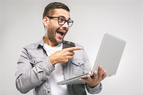 흰색 배경에 서 있는 동안 노트북을 들고 웃 고 있는 셔츠에서 재미 있은 젊은 잘생긴 남자 즐거운 시간 보내세요 가까운에 대한