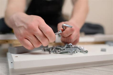Furniture Assembler Takes Screw Hex Key In Hand Close Up The Concept