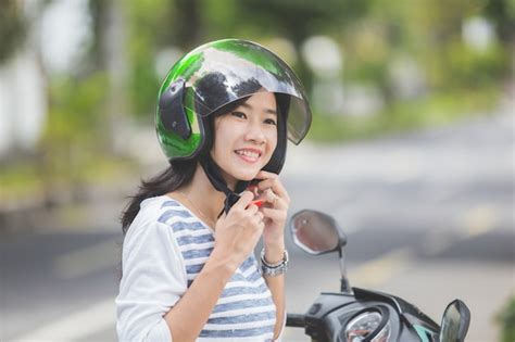 Premium Photo Woman Put Her Helmet On Before Riding A Motorbike