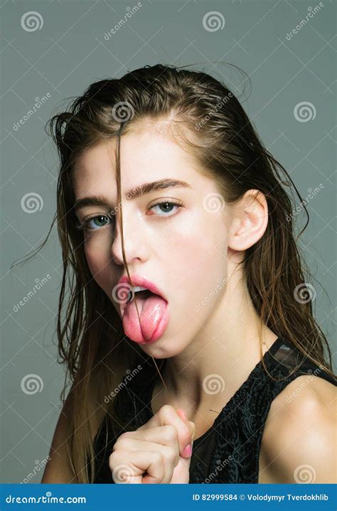 Довольно сексуальная девушка показывает язык Стоковое Фото изображение насчитывающей рот