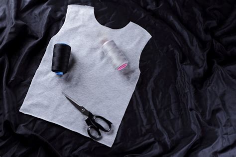 바느질 어린이 수 제 셔츠 회색 직물 그리고 어두운 배경에 스레드입니다 조정의 과정 회색 직물가 위 실 술 및 검은 페인트 T셔츠 빈 가위에 대한 스톡 사진 및 기타 이미지