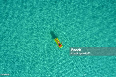 세이셸의 투명한 청록색 바다에서 수영 매트리스에서 수영하는 슬림 한 여성의 공중 보기 소녀와 여름 바다 풍경 아름다운 파도 다채로운 물 드론에서 보기 건강한 생활방식에 대한