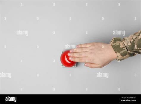 Serviceman Pressing Red Button Of Nuclear Weapon On Light Gray Background Top View With Space