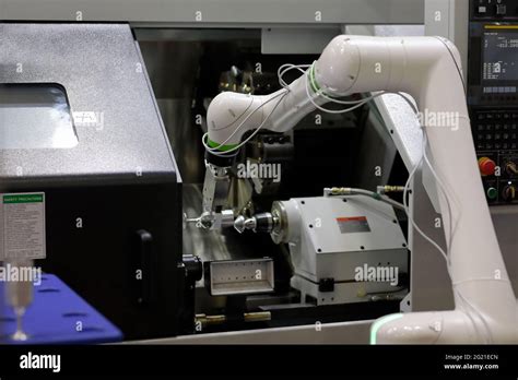 CNC Lathe Machine And Collaborative Robot Loading The Workpiece Stock