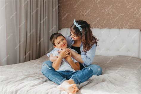 Mamá E Hijo Están Sentados En La Cama Abrazándose Y Divirtiéndose