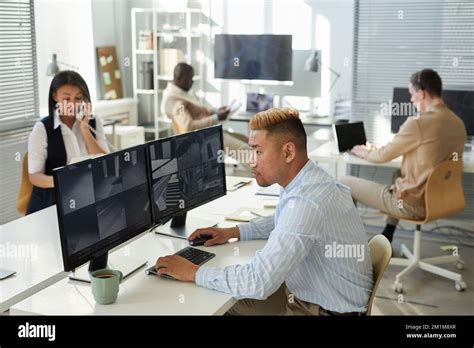 Side View Portrait Of Asian Young Man Looking At Surveillance Camera