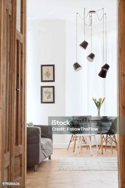 세련 되 고 현대적인 레스토랑 및 디자인 포스터 소파 및 패밀리 테이블 거실 공간을 엽니다 밝고 화창한 식물과 갈색 나무 마루와 방 창문에 대한 스톡 사진 및 기타 이미지