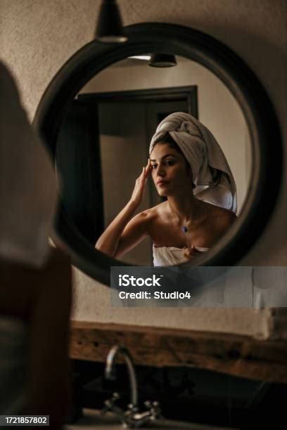 수건에 싸인 채 화장실에 서서 거울에 비친 자신을 감상하며 꼼꼼하게 양치질을 하는 히스패닉 여성의 자기 관리의 순간 25 29세에 대한 스톡 사진 및 기타 이미지 Istock