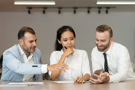 심각한 비즈니스 사람과 작업 데스크에서 스마트폰을 사용 하 여 3 명에 대한 스톡 사진 및 기타 이미지 3 명 가리키기 개념 Istock