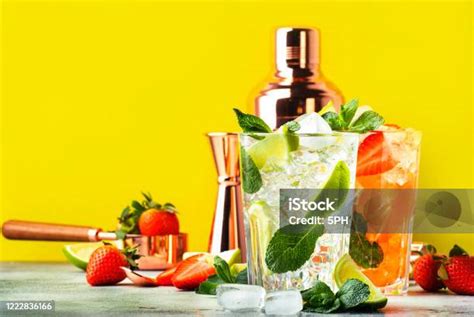 라임 민트 딸기 얼음을 노란색 배경에 유리로 놓은 신선한 모히토 칵테일 세트 여름철 차가운 알코올 무알코올 음료 음료 및 칵테일