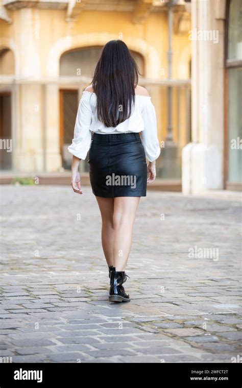 Rear View Woman Wearing Short Leather Skirt Walking Away Outdoors Stock