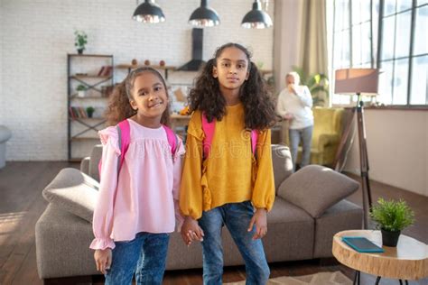 Two Cute Dark Skinned Girls Standing In The Room And Smiling Stock