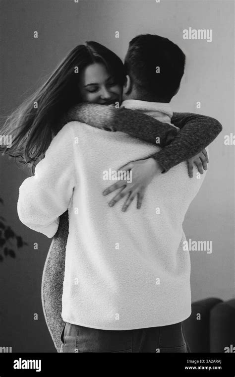 Couple Shares An Intimate Moment While Hugging In Cozy Indoor Setting